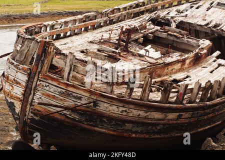 An large, old, wrecked wooden boat, in dry dock, showing the rotting ...