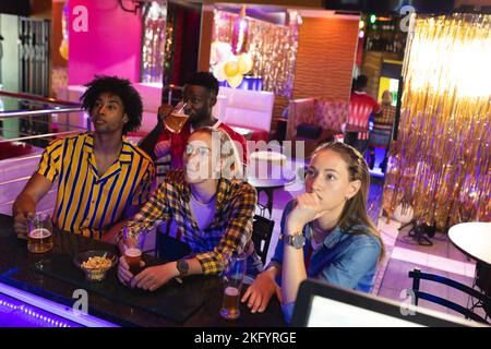 Four male friends play ball on the beach at dusk Stock Photo - Alamy
