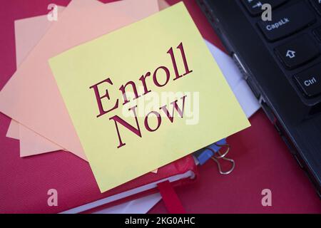Enroll Now. Text on adhesive note paper. Event, celebration reminder ...