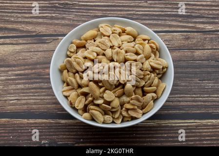 Pealed Peanuts in a bowl isolated on wooden background Stock Photo - Alamy