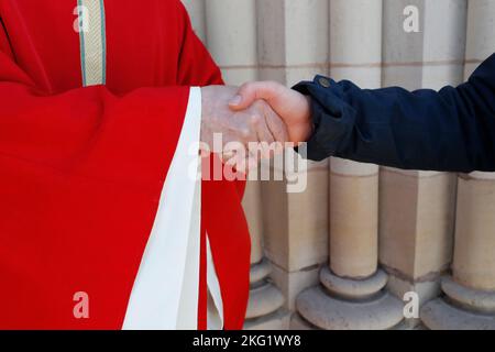 Catholic church. Catholic priest and a parishioner. Handshake ...