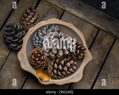 An old, pottery bowl full of pine cones in wooden box. Rustic Stock ...