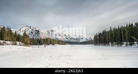 Unrecognizable people skate and play hockey on frozen Johnson Lake in ...