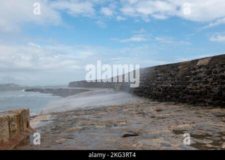 wave splashing over The World Famous Cobb at Lyme Regis Dorset England ...