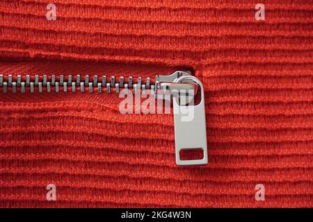 Silver colored metal zipper on a red fabric Stock Photo - Alamy