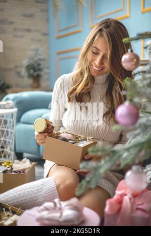Top view cozy female opening craft festive gift box full beauty ...