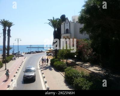 A drone shot of a girl with bicycle on a street with a shadow of street ...