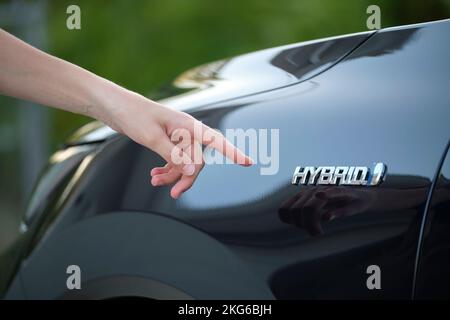 Human hand showing hybrid car sign on new effective vehicle Stock Photo ...