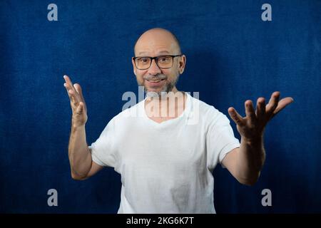 The portrait of a bearded bald man imitating something with his hands ...