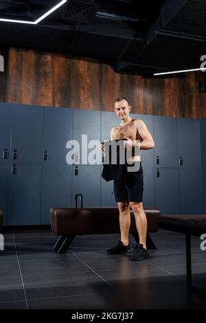 Handsome men changing clothes in locker room Stock Photo - Alamy