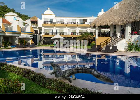 A crocodile sculpture by the pool at a resort hotel on Chahue Beach in ...