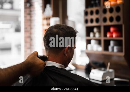 A closeup shot of a barber cutting a male's hair at the salon Stock ...