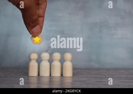 Hand holding a star over the team. Awarding, appreciation and reward ...