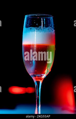 A vertical image of a glass of Champaign in the dark background with ...