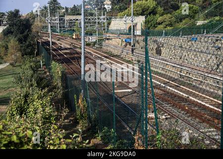 Railroad tracks next to a cliff by the sea on a sunny day Stock Photo ...