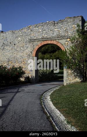 Path going through an arch of an ancient bounday wall in a park Stock ...