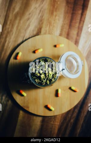 Doctor holding jar of marijuana pills closeup Stock Photo - Alamy