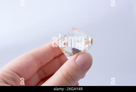 Hand holding a transparent diamond on a white background Stock Photo ...