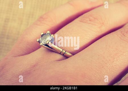 Hand wearing a fake diamond ring on a textured background Stock Photo ...