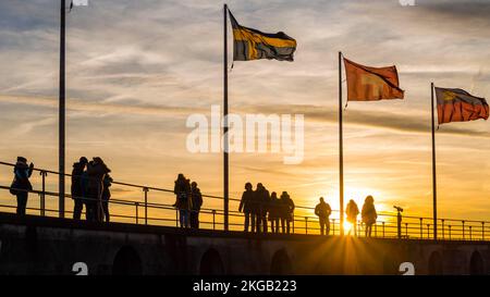 People, silhouettes, flags, harbour in Lindau on Lake Constance ...