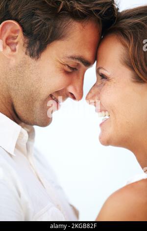 A moment between a happy couple as they look lovingly into each other's ...