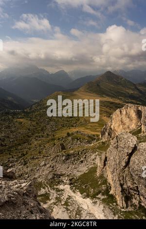 A vertical shot of the Passo Falzarego mountains under the cloudy sky ...