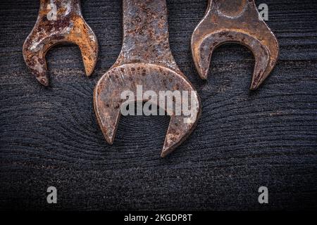 Collection of rusted spanner wrenches on wood board construction ...
