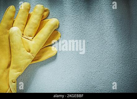 Leather protective gloves on concrete background construction concept ...