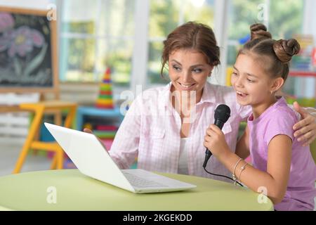mom and daughter sing into the microphone Stock Photo - Alamy