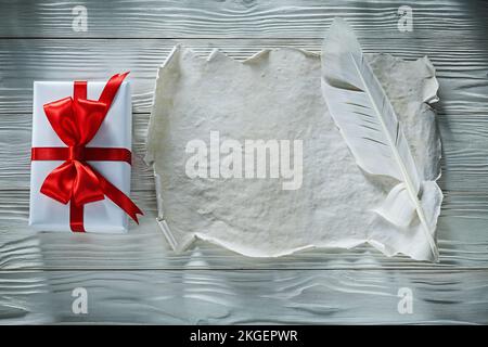 Plume vintage paper sheet wrapped gift box on wooden board Stock Photo ...