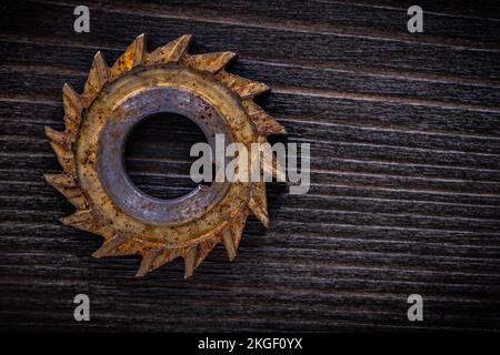 Rusted sharp rotary cutter on vintage wood board construction concept ...