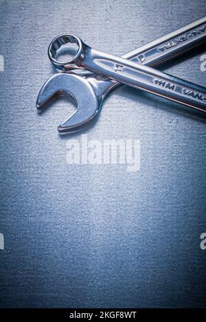 Stainless steel flat spanner and hook spanner on a metallic background ...