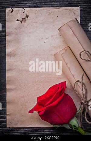 Vintage corded paper rolls red natural rose on wooden board Stock Photo ...
