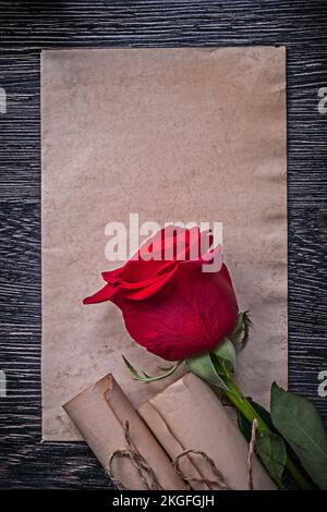Vintage corded paper rolls red expanded rose on wooden board Stock ...