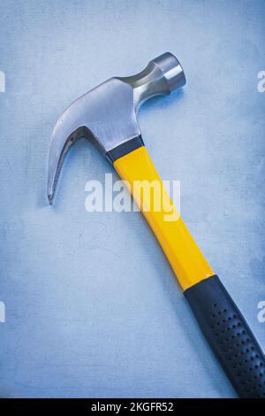 Yellow claw hammer with rubber handle on metallic background ...