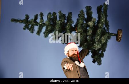 Businessman with raging face holds Christmas tree up Stock Photo - Alamy