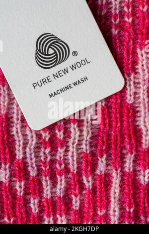 Pure New Wool logo in woman's pink jumper - machine wash Stock Photo ...