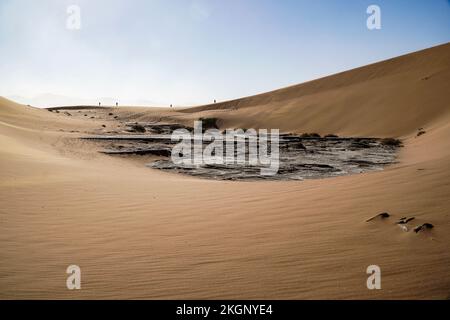 A mesmerizing scene of a salt and clay pan surrounded by high red dunes ...