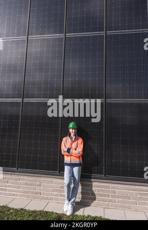 Smiling engineer leaning with arms crossed on solar panels Stock Photo ...