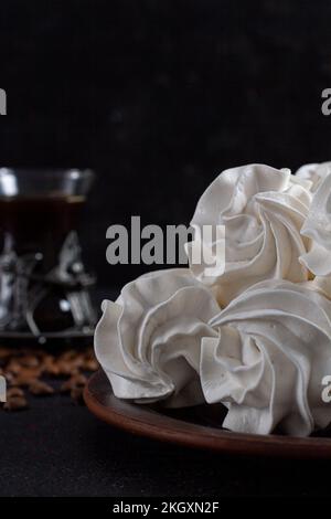 zepfyr on a dark background in a plate in the background - a cup of ...