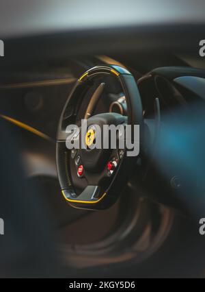 Vertical closeup shot of a steering wheel and rusty equipment on a boat ...