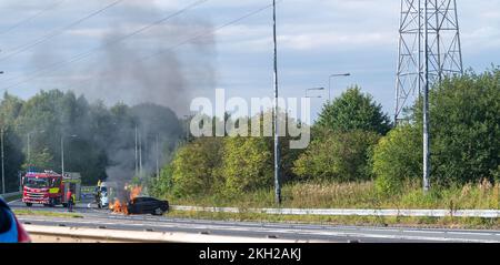 Fire crew putting out a car fire after an incident on the Motorway, UK ...