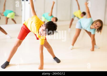 Preteen boy doing stretching workout before training in choreography ...