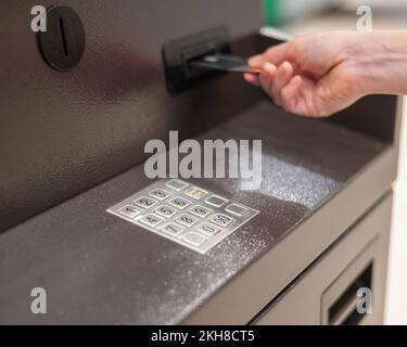 Faceless woman inserts bank card at ATM Stock Photo - Alamy