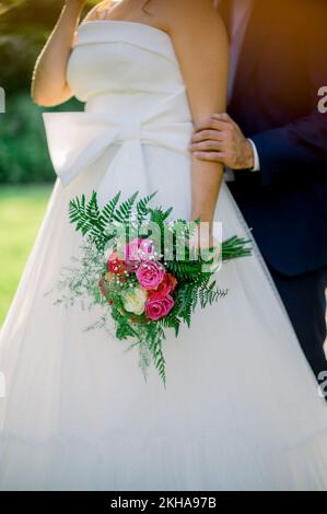 Crop anonymous bride in elegant wedding white dress standing on clean ...
