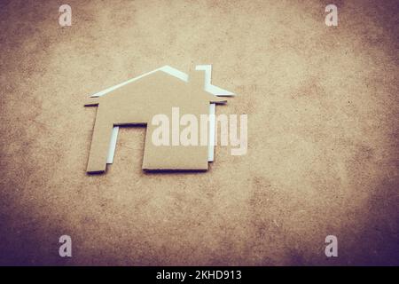 Little paper houses on a brown background Stock Photo - Alamy