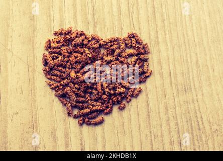 Brown leaves form heart shape on brown background Stock Photo - Alamy
