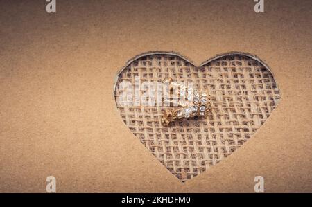Crown seen through heart shape cut out of cardboard Stock Photo - Alamy