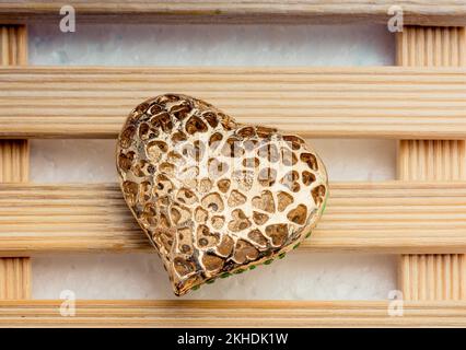 Gold color heart shaped l decorative object in view Stock Photo - Alamy
