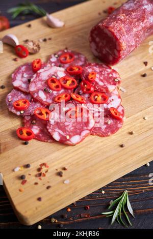 Traditional salami sausage on wooden cutting board with spices Stock ...